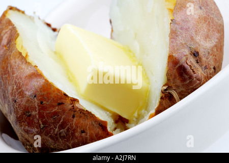 A baked jacket potato with butter melting inside Stock Photo - Alamy