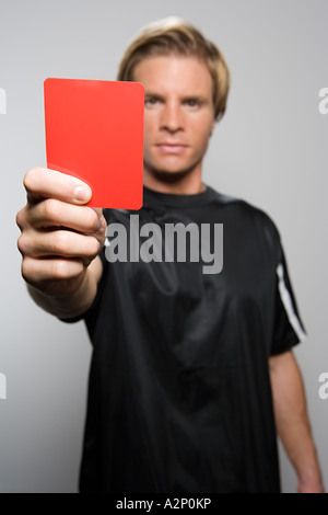 Referee holding ball and showing a red card to a football or soccer ...