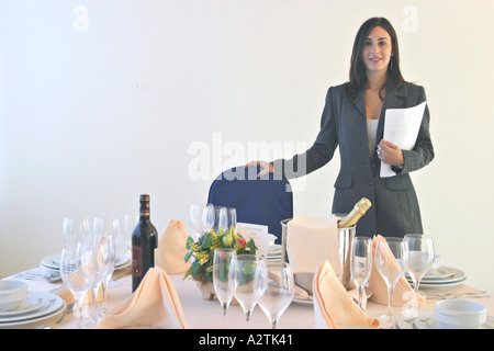 M.S. of young hostess with clipboard showing a fancy banquet table or ...