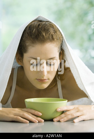 Woman leaning over bowl, towel over head Stock Photo - Alamy
