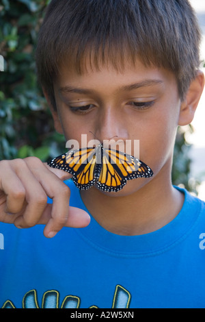 Boy holding a Monarch butterfly Stock Photo - Alamy