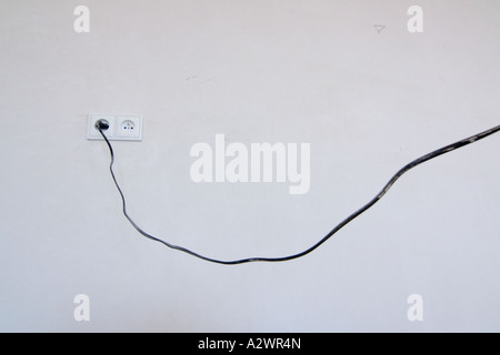 Extension cord pulling out of electric outlet Stock Photo - Alamy