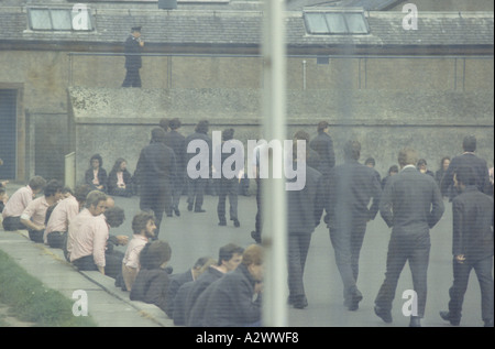 Prison officers and prisoners in the exercise yard of HMP Woodhill ...