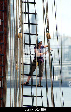Female crew member onboard a tall masted ship working high up in the ...