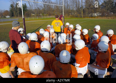 Football coach meeting with team to discuss finer points of the game ...