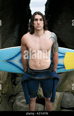 Young hispanic man with tattoos standing over yellow background smiling ...