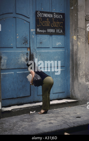 Woman looking through keyhole in grey surface Stock Photo - Alamy