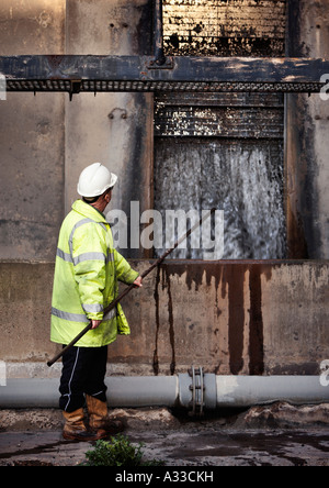Workman adjusting the sluice gates of the waste ash washing pits at a ...