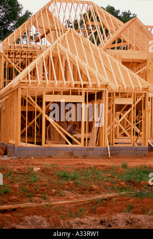 Timber frame house construction. Joiners in a workshop making sections ...