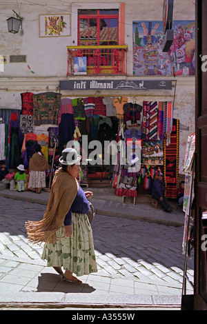 An indigenous Aymara woman dressed in traditional clothing carries her ...