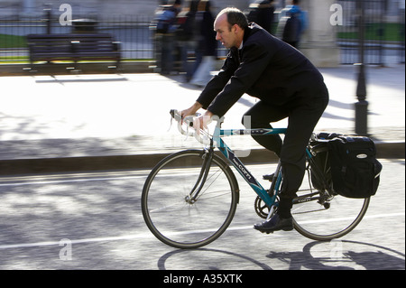 balding man cycling past on old style racing bike with saddlebags on ...