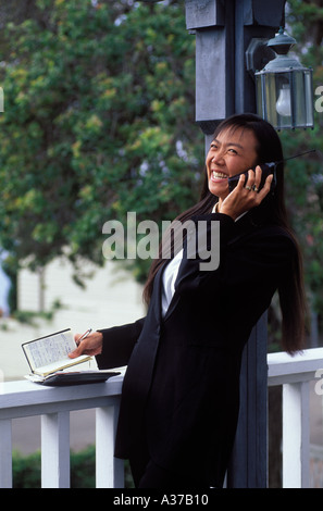 Businesswoman using cell phone in office Stock Photo - Alamy