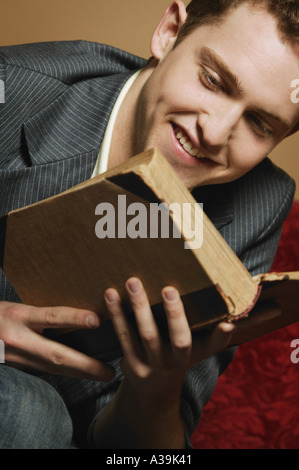 portrait of young man reading red book Stock Photo - Alamy