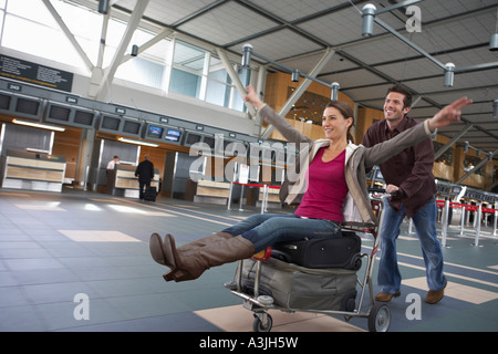 man and woman running through an airport in a rush to catch their ...