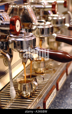 Fresh coffee in espresso coffee machine on wooden table Stock Photo - Alamy