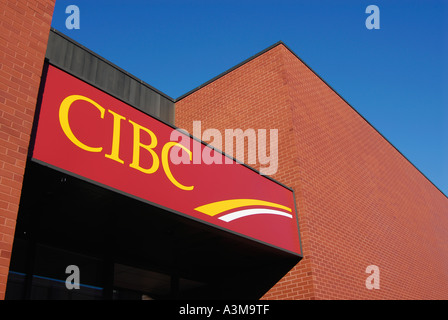 CIBC bank sign and logo against a brick building background and blue ...