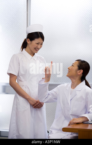 young Asian woman doctor talking smartphone pointing gesture while ...