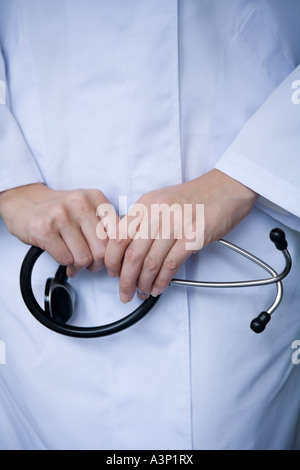 Young woman doctor with stethoscope holding clipboard in her hands in ...