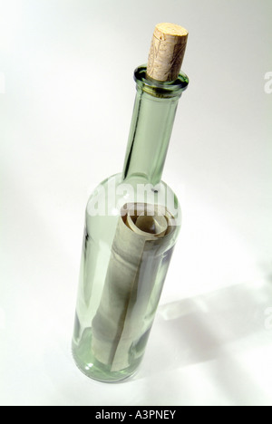 Corked glass bottle with rolled paper note and seashells on sand ...