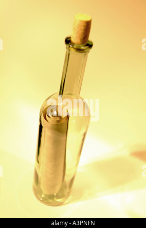 Corked glass bottle with rolled paper note and seashells on sand ...