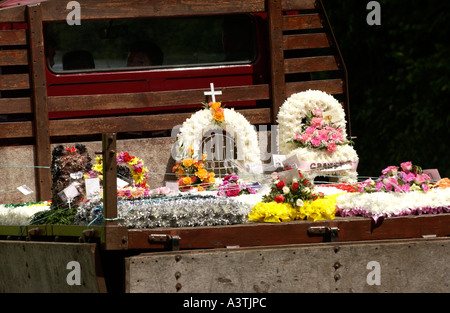 Traditional gypsy funeral cortege with flowers carried on flatbed truck ...
