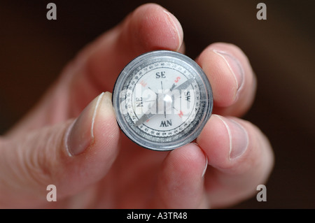 Hand holding a toy Compass Stock Photo - Alamy