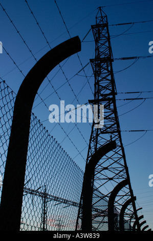 Electrical power pylon behind a barbed wire security fence in a sub ...