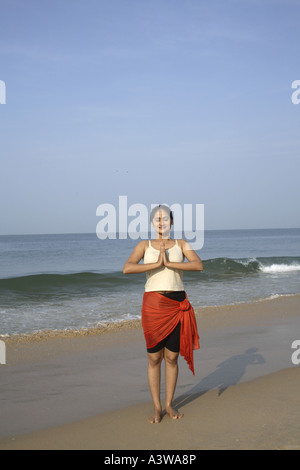 Young smiling women exercising yoga poses on sunny beach by ocean Stock ...