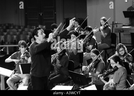 Music Director leads a high school band in practice for upcoming ...