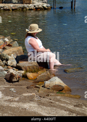 A fat woman relaxing in the sun on a cruise ship in the Caribbean, West ...