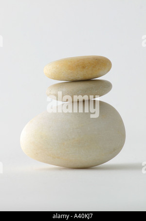 Three pebbles balanced with a white background Stock Photo - Alamy