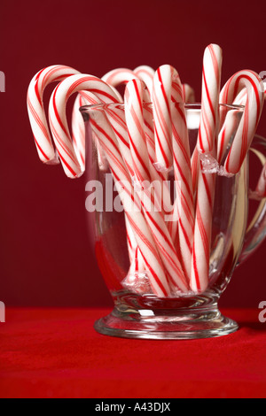 Cup with sweet candy canes and Christmas decor on wooden background ...