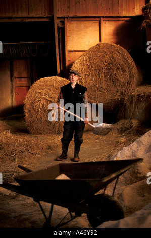Wheelbarrow and shovel near a hay bale in a garden Stock Photo - Alamy