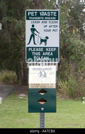 Close up of a Pet Waste Station with gate and building in the blurry ...