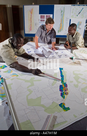 Geologists examining maps and discussing exploration targets, geology ...