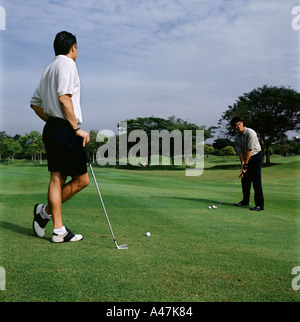 Two men playing golf Stock Photo - Alamy