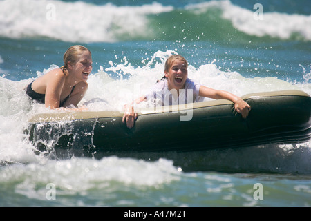Two teenage girls ride Inflatable donut being pulled by a speedboat on ...