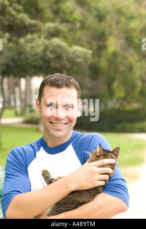 Young man carrying cat, portrait Stock Photo - Alamy