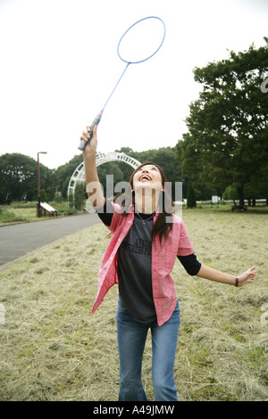 Young woman playing badminton with racket on white background Stock ...