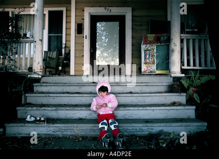 Girl wearing roller skates sitting on road at park Stock Photo - Alamy