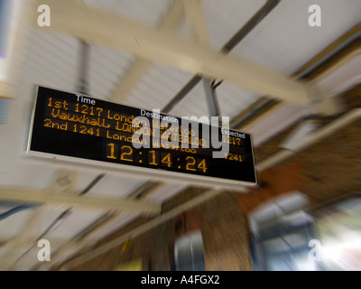 Departures electronic train board and waiting passengers, Milan Central ...
