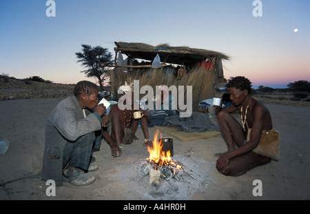 Bushmen San sitting outside their grass homestead Kalahari Northern ...