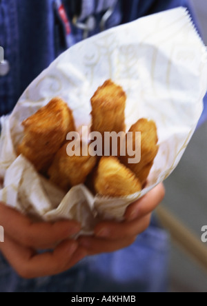 A person holding a churro in their hand Stock Photo - Alamy