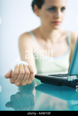 Woman squeezing stress ball while working in office Stock Photo - Alamy