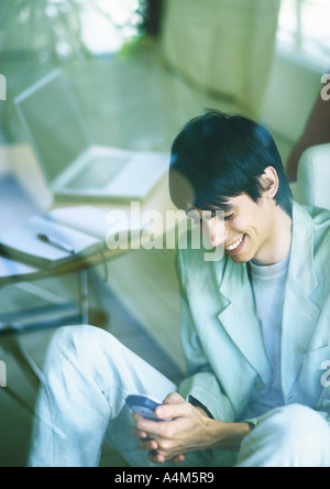Pleased young man reading text message on smartphone Stock Photo - Alamy
