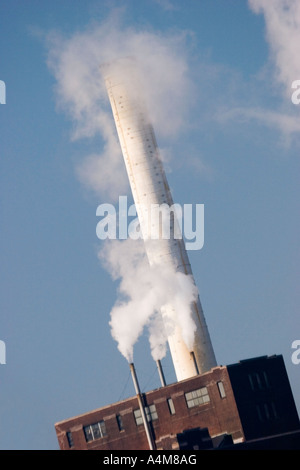 A tall smokestack rises above a brick factory building Stock Photo ...