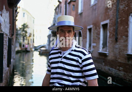 Close up of gondolier wearing traditional hat with red ribbon in Venice ...