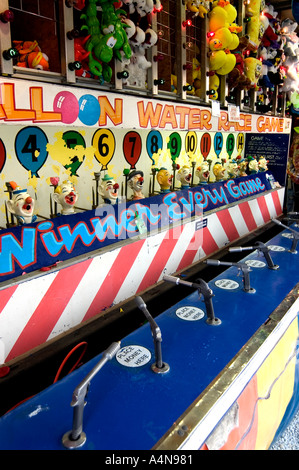 Carnival midway Balloon Race game operator posing for the camera in ...