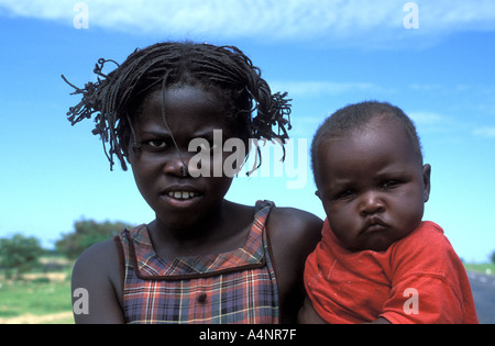 Girl of Ovambo tribe is carrying toddler near Kamajanga Ovamboland ...