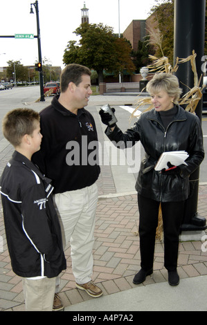 Female reporter does an in the street interview with a father and son ...